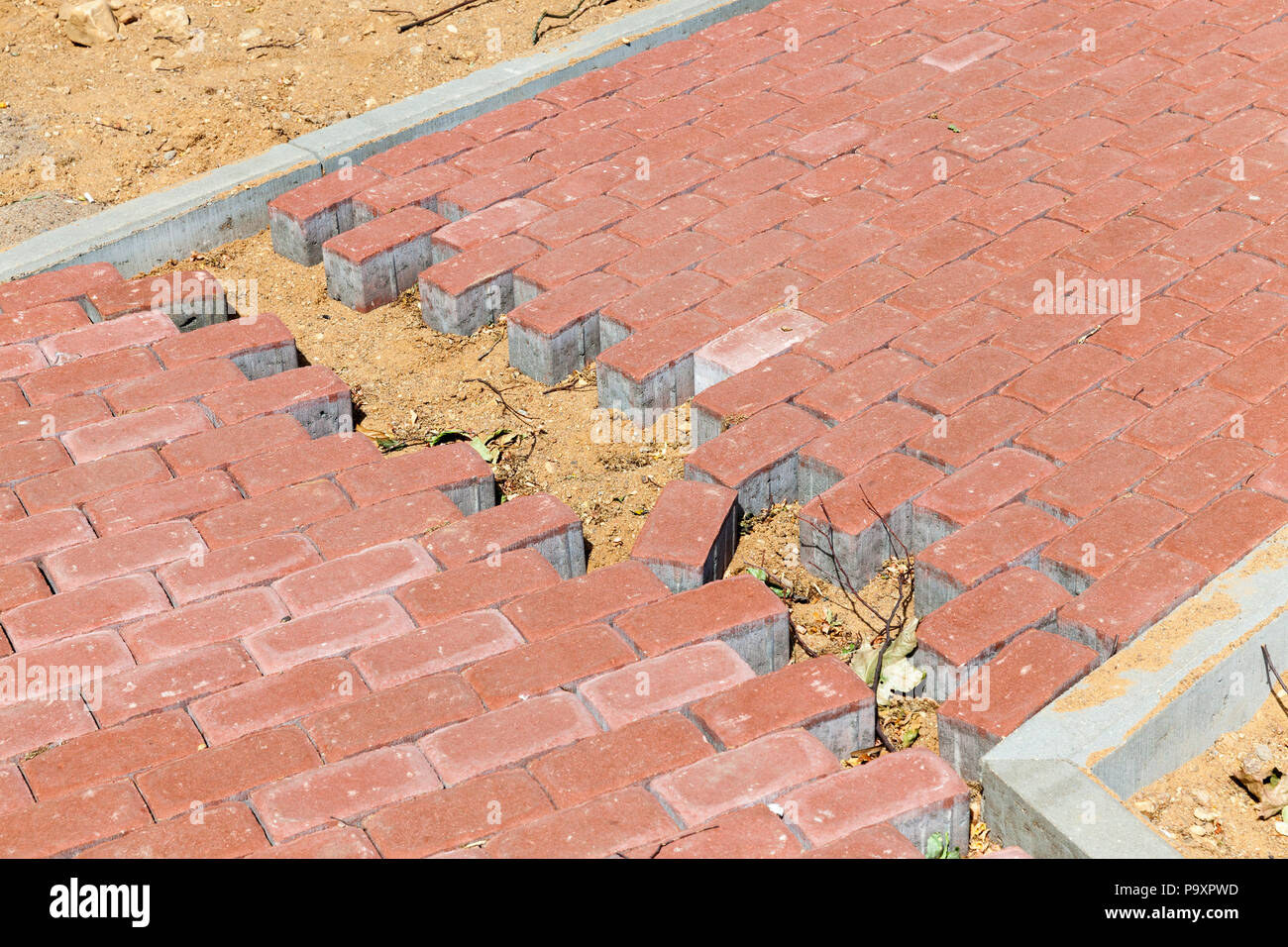 The place of connection of several pedestrian paths of red tiles during ...