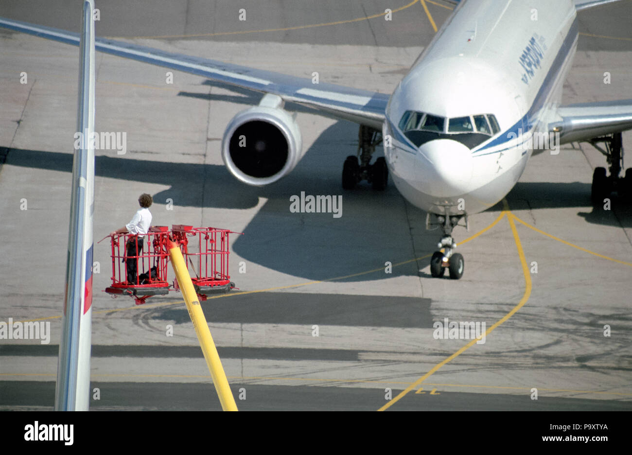 A technician servicing airplane vertical fin looks at Aeroflot's Boeing ...