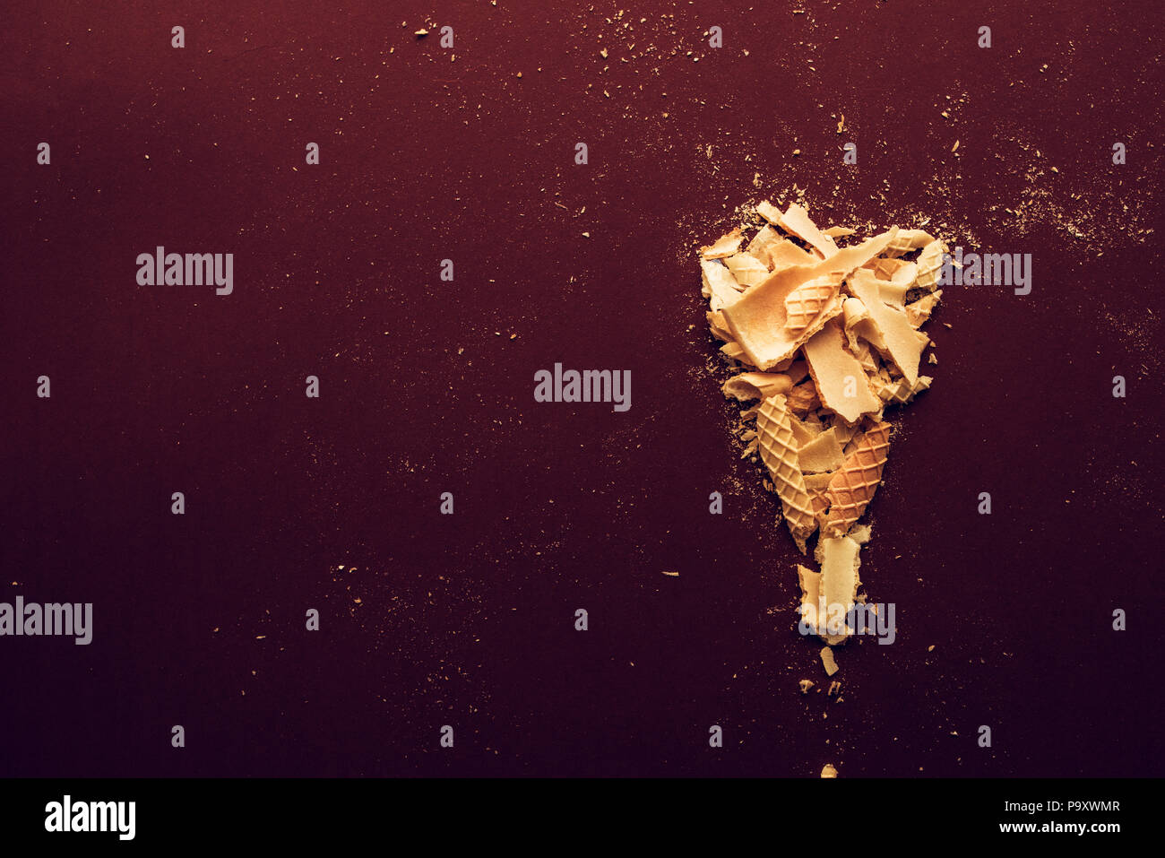 Crushed ice cream cone on dark brown background, flat lay Stock Photo ...