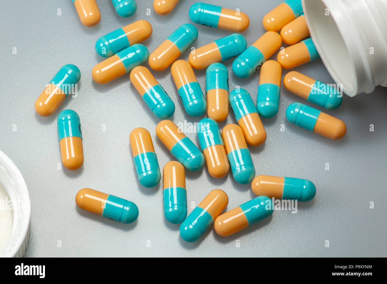 White large pills falling out of a large brown pill bottle Stock Photo ...