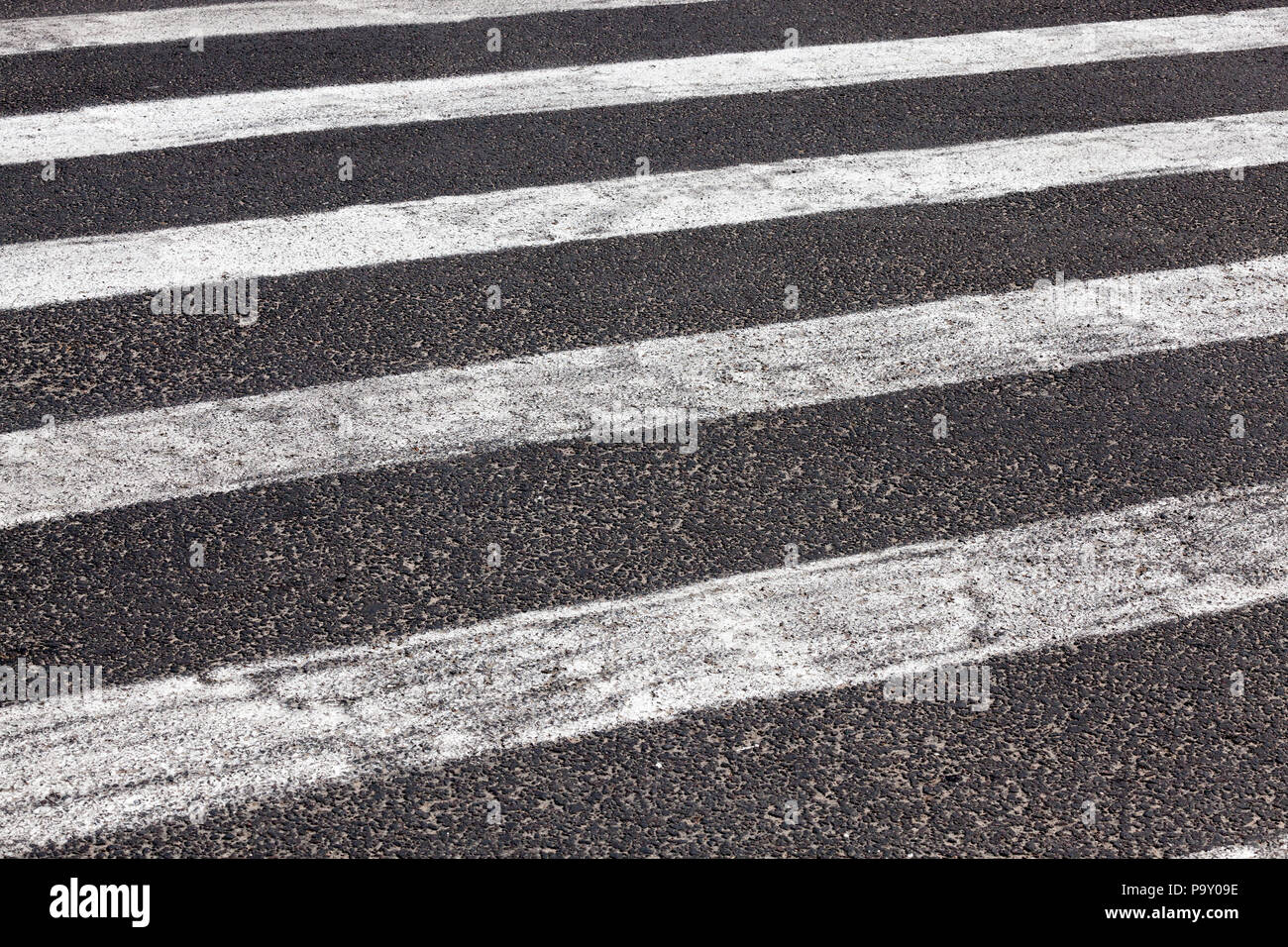 old worn-out road marking of white on the site of a pedestrian crossing ...