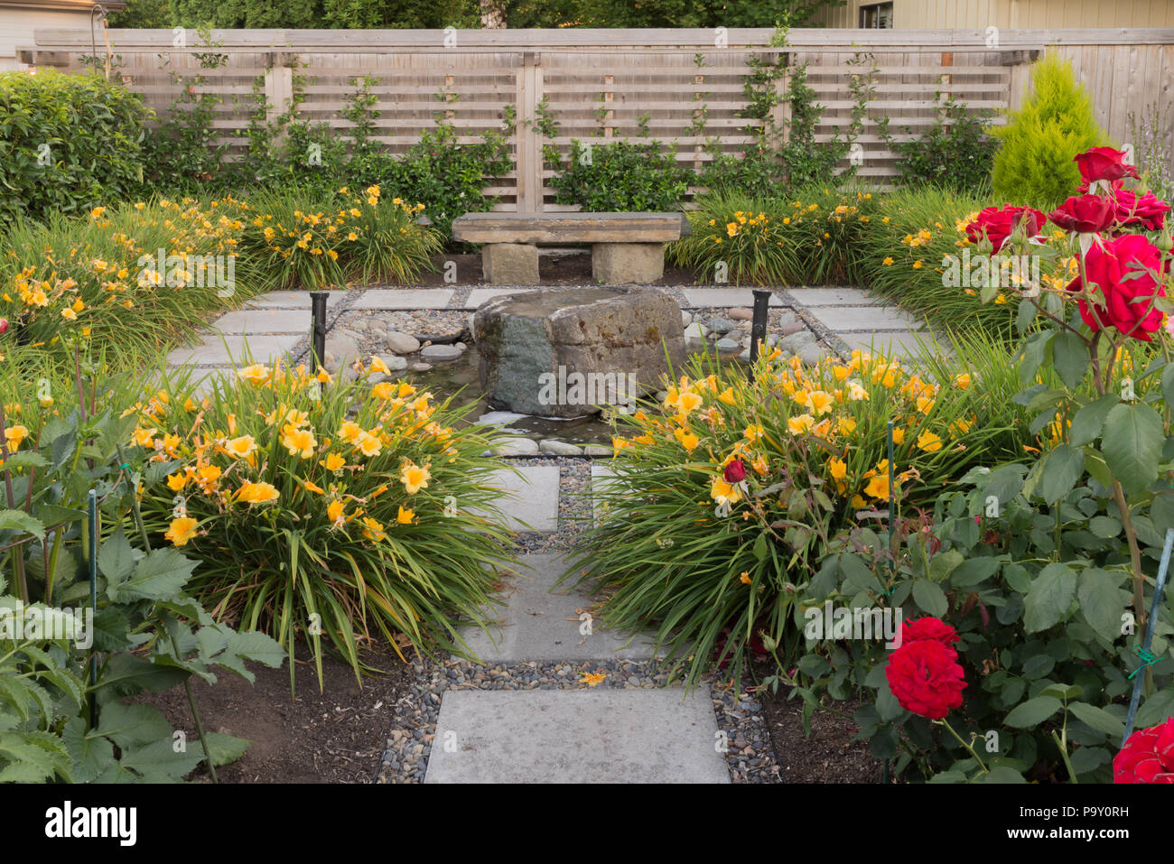 A meditative stone fountain hidden in a backyard garden Stock Photo - Alamy