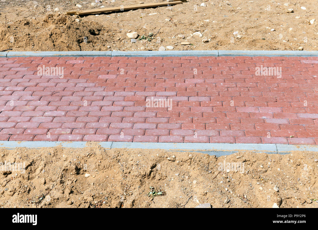 construction of a new walking path in a park of red tiles, a ...