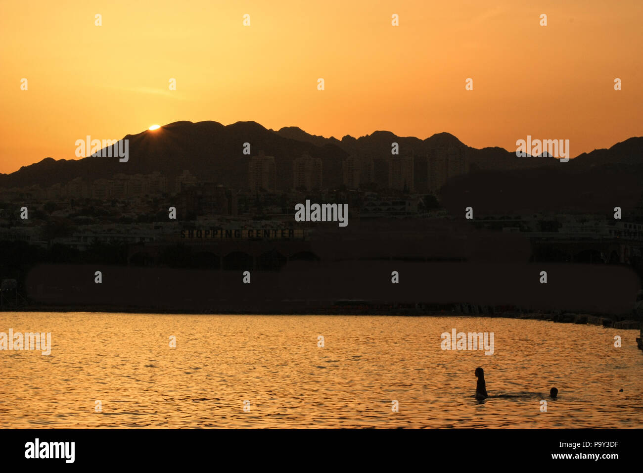 Kids bathing at sunset in the Israeli town of Eilat with mountains of ...