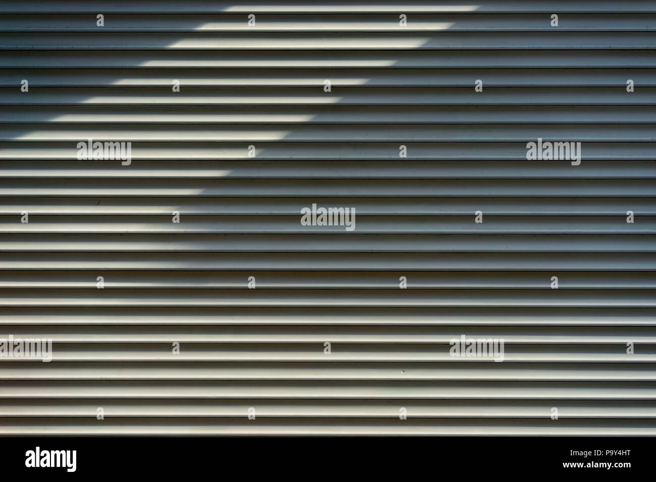 Long shadows on the rhythmic horizontal striped iron surface Stock ...