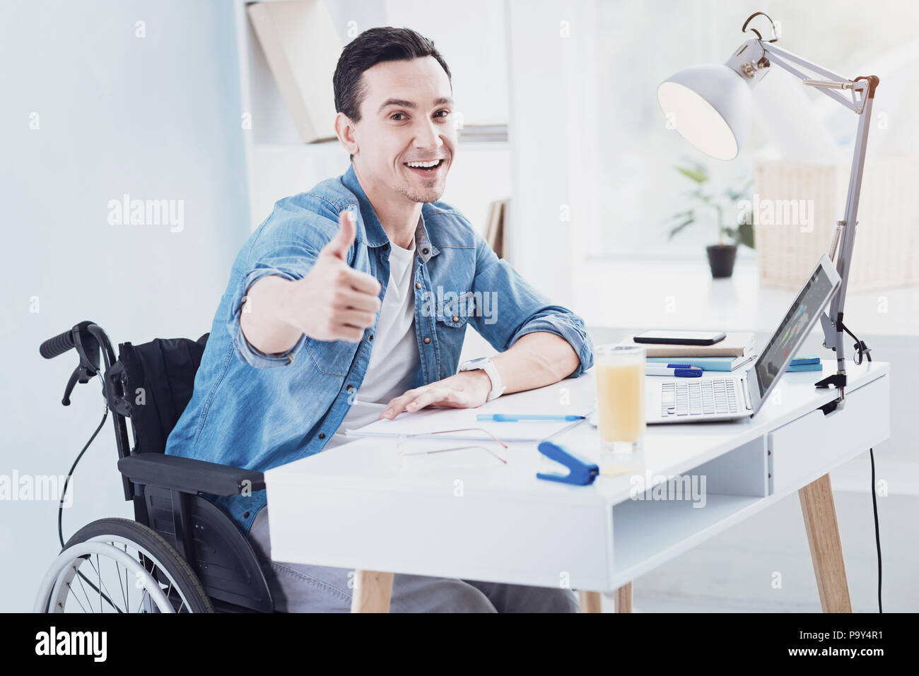Pleased male person raising thumb Stock Photo - Alamy
