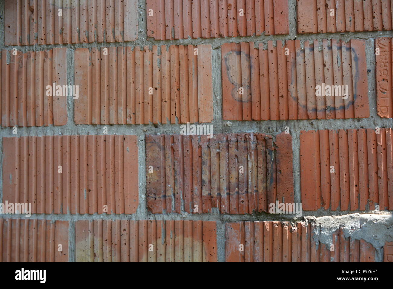 Stylish corrugated red clay bricks, brickwork with gray cement as ...