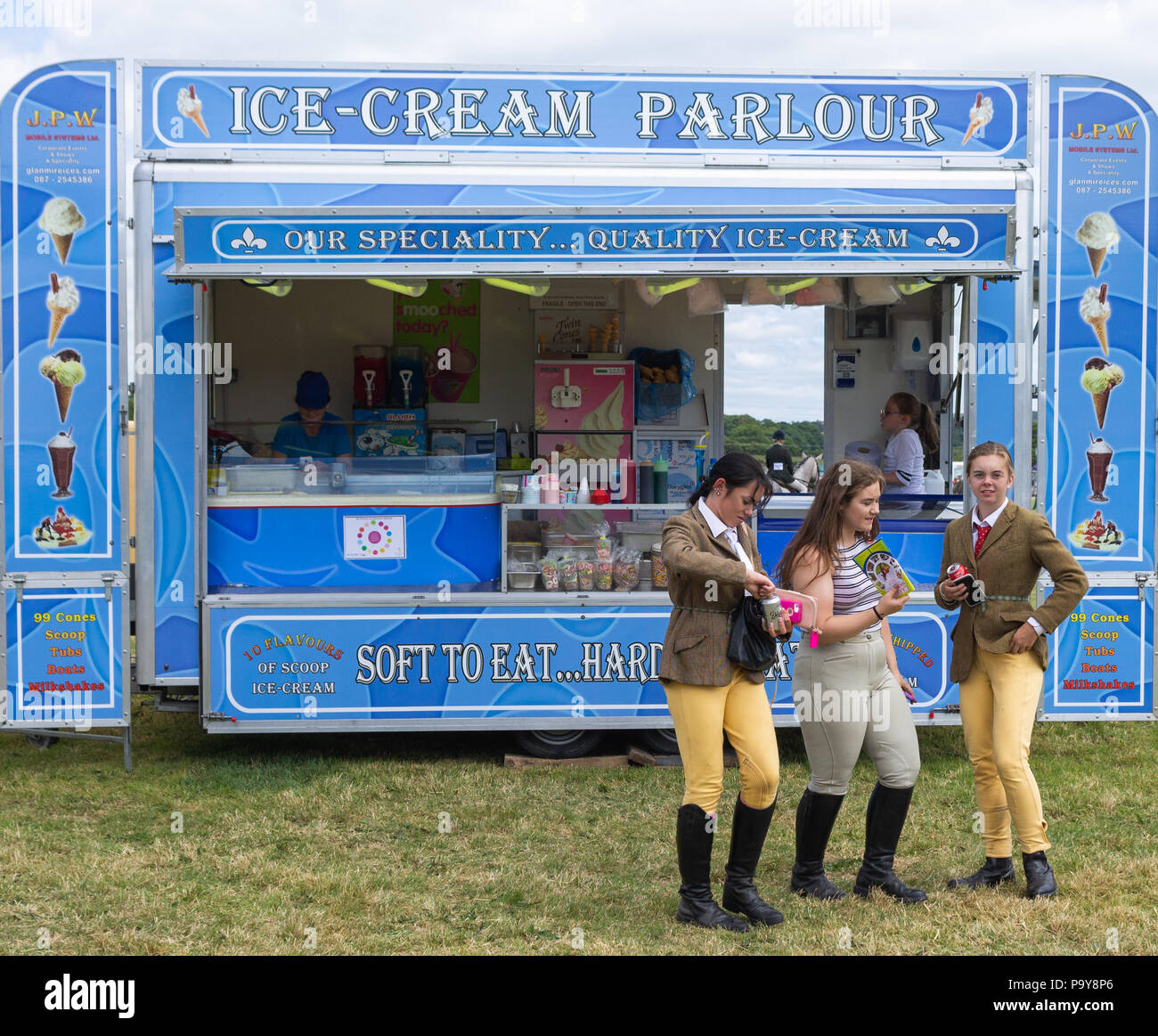 three or 3 young ladies in horse riding cloths visiting an ice cream ...