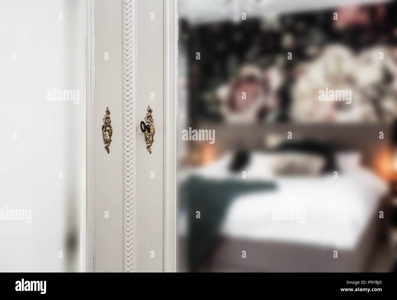 Antique vintage mirror on closet with golden lock and key in bedroom ...