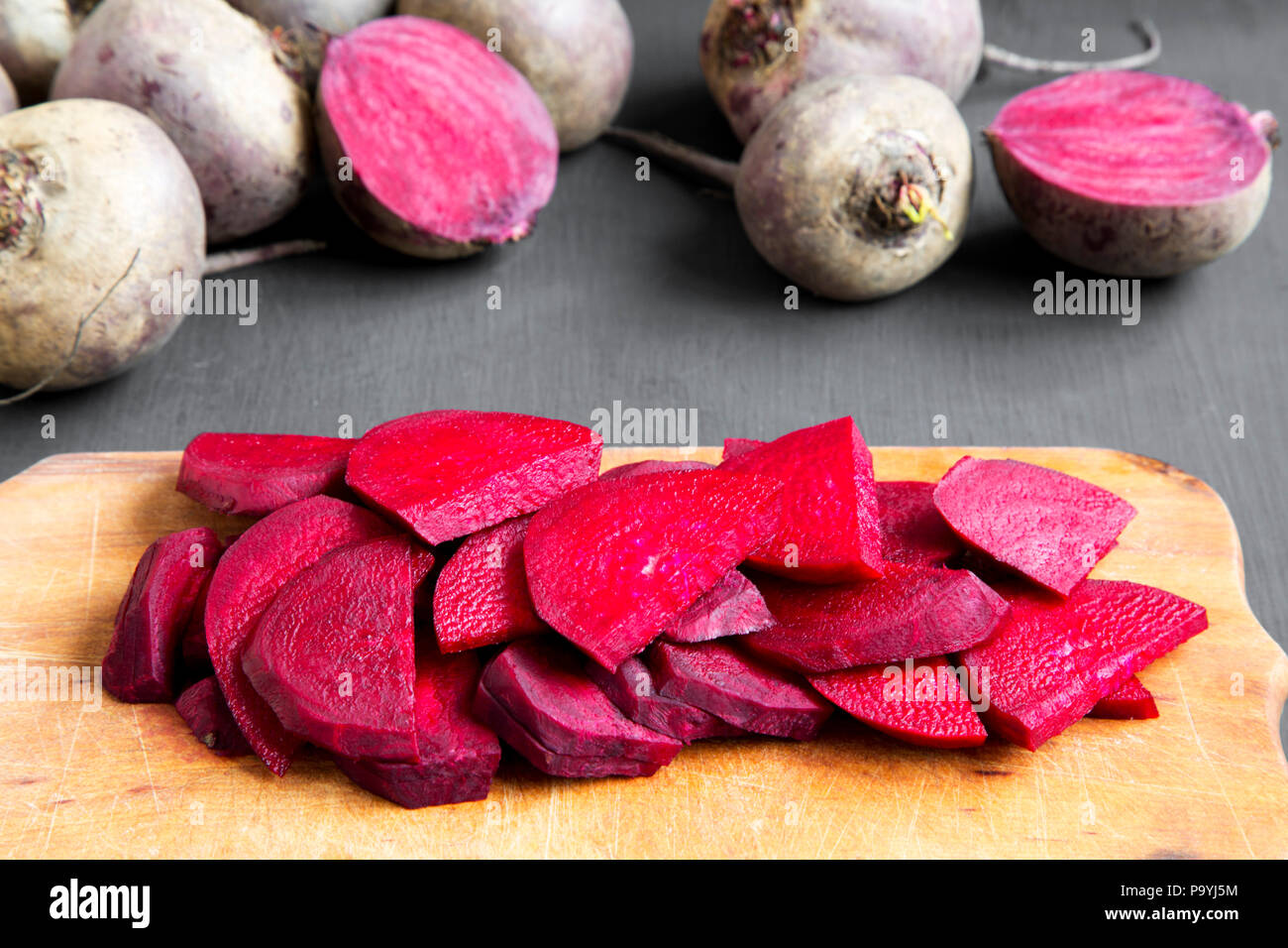 Chopped red beetroot on wooden chopping board, side view. Closeup ...
