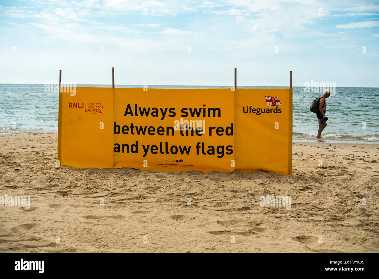 Warning notice on beach to swim between the red and yellow flags, with ...