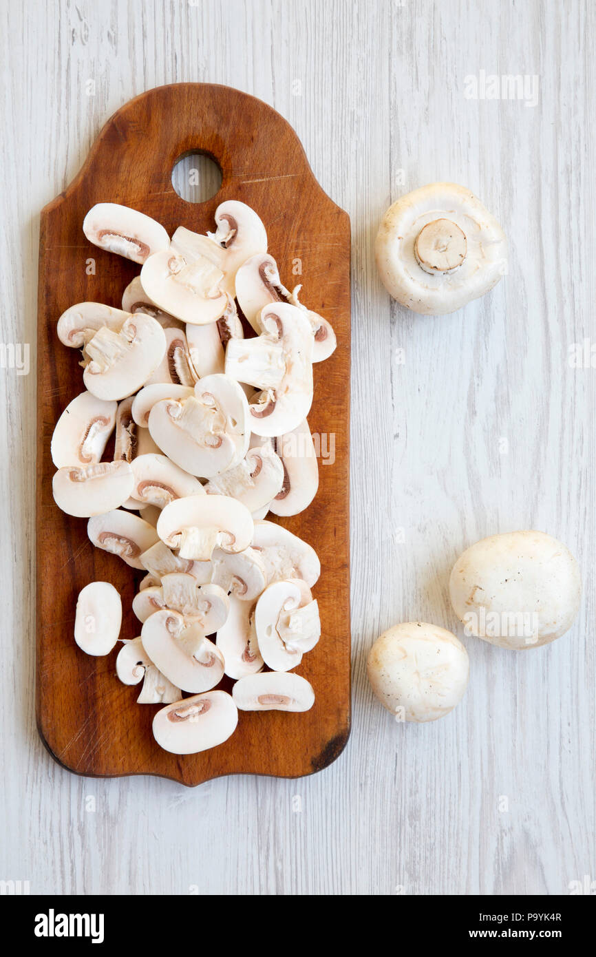 Chopped mushrooms on wooden chopping board, view from above. White ...