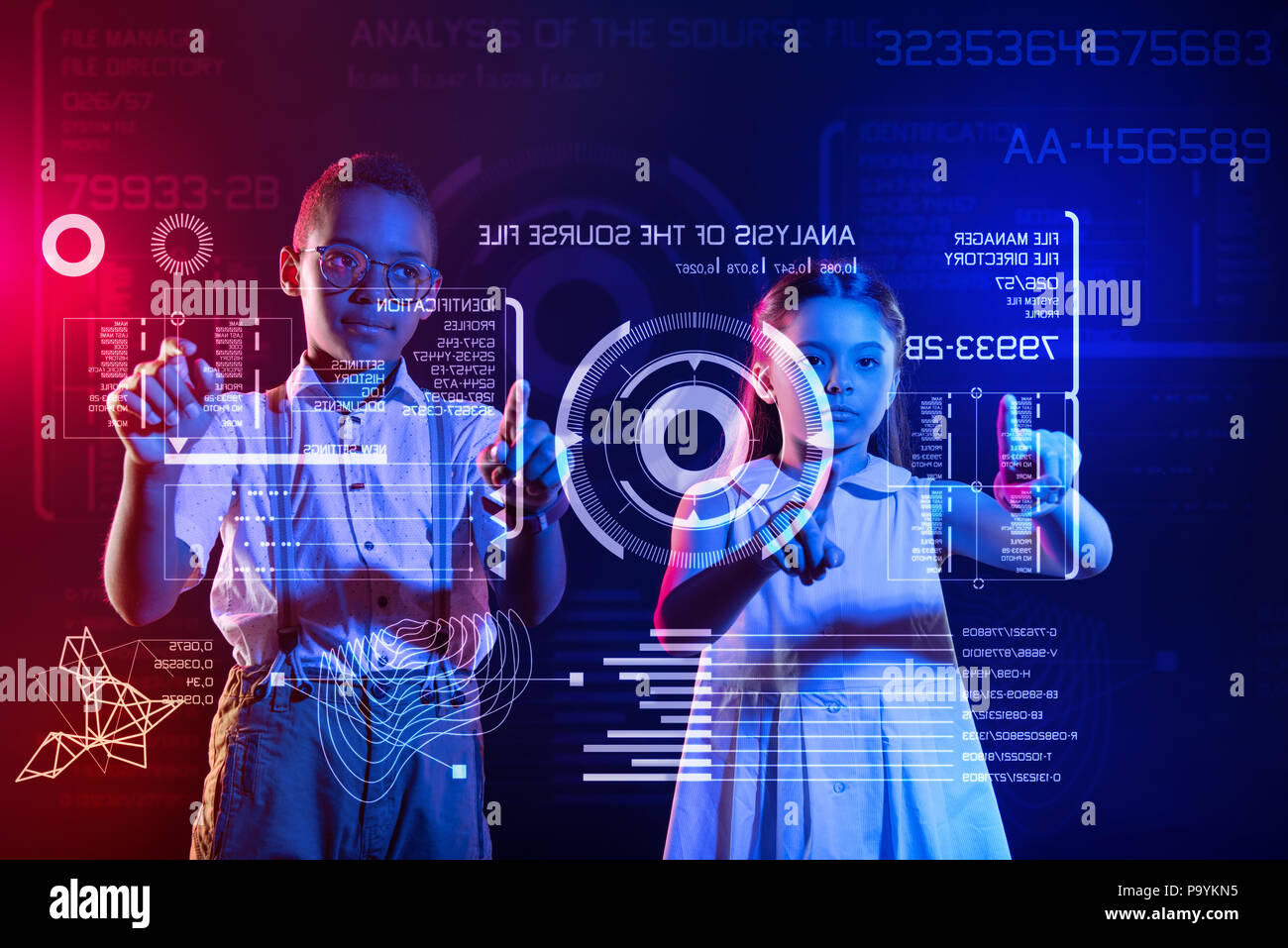 Calm kids looking attentively at the screen while touching it Stock ...