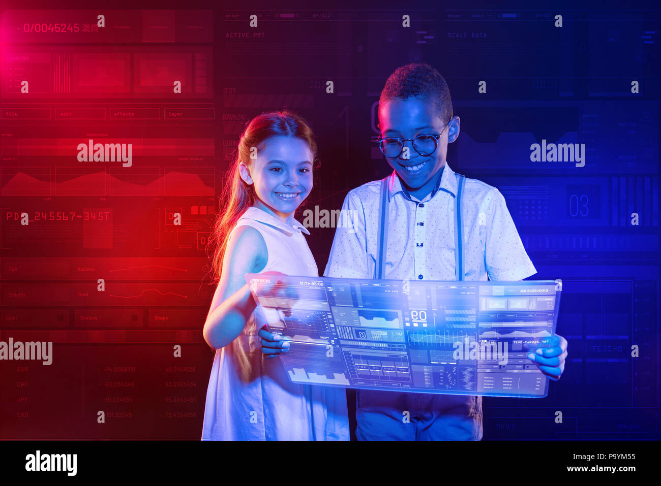 Happy kids smiling while holding a transparent gadget Stock Photo - Alamy