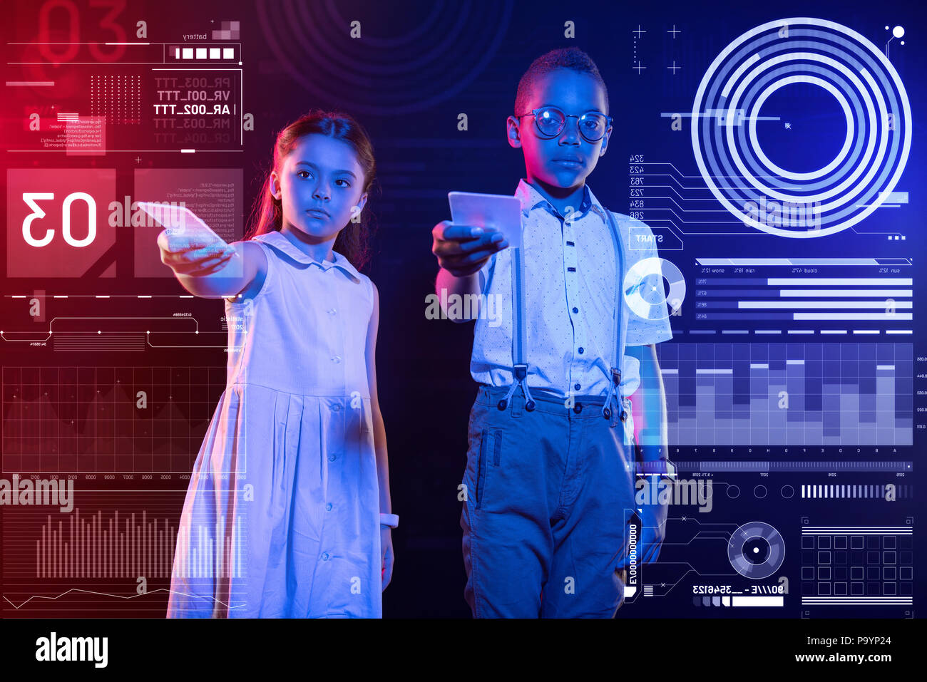 Modern kids looking serious while using remote controls Stock Photo - Alamy