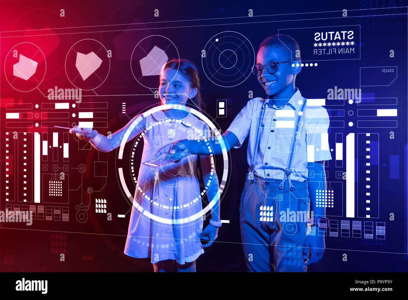 Expressive kids smiling while using futuristic technologies Stock Photo ...