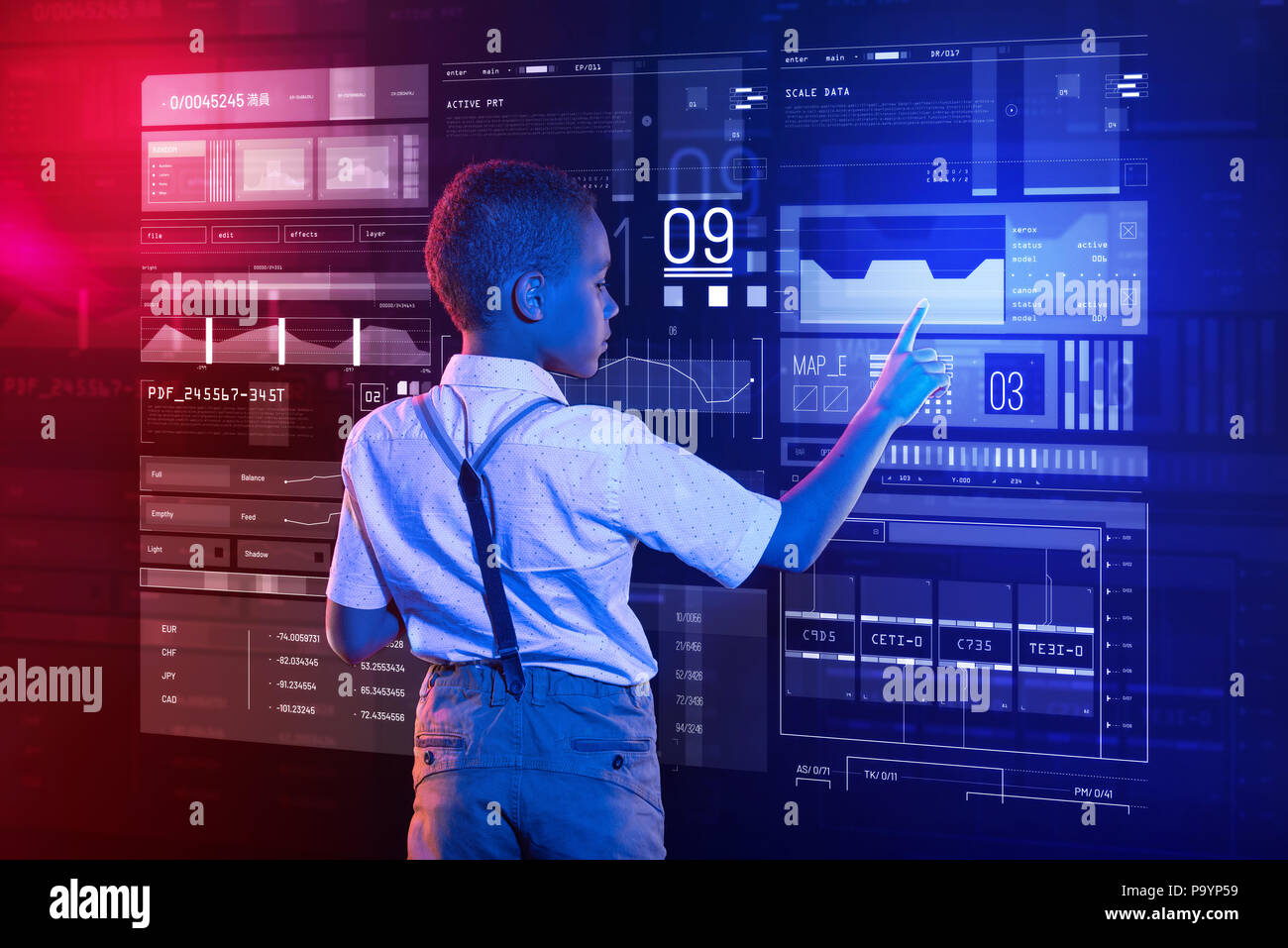 Concentrated boy touching the screen while studying alone Stock Photo ... Concentrated boy touching the screen while studying alone Stock Photo ...