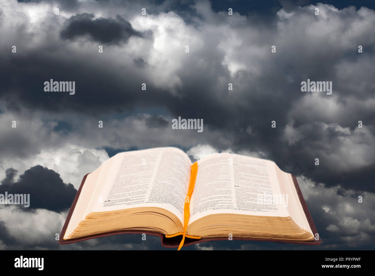 Open bible book on dramatic sky background Stock Photo - Alamy