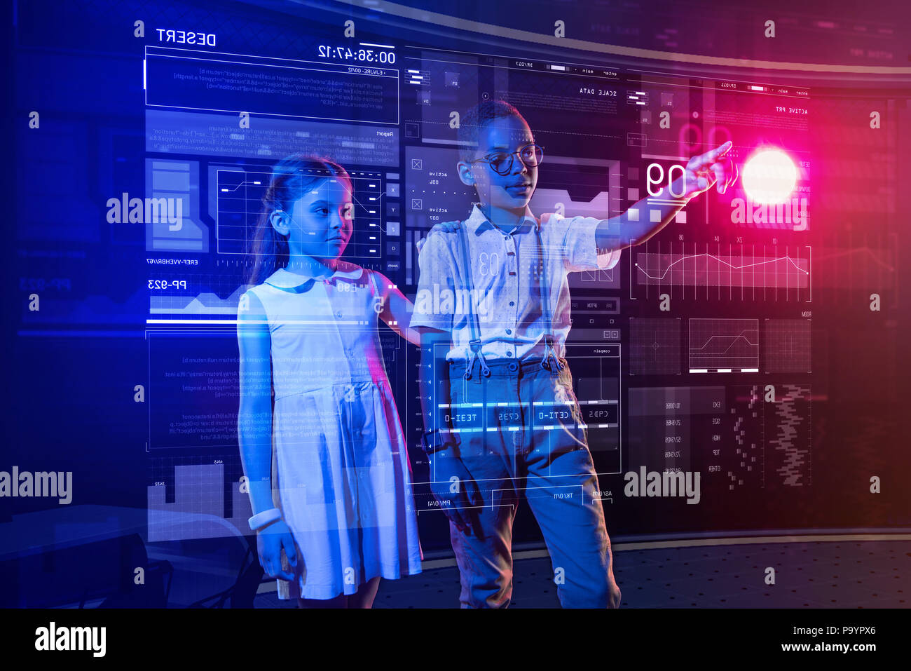 Calm boy pointing to the screen and a girl looking at it Stock Photo ...