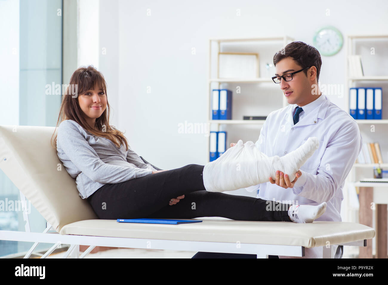 Doctor examining patient with broken leg Stock Photo - Alamy