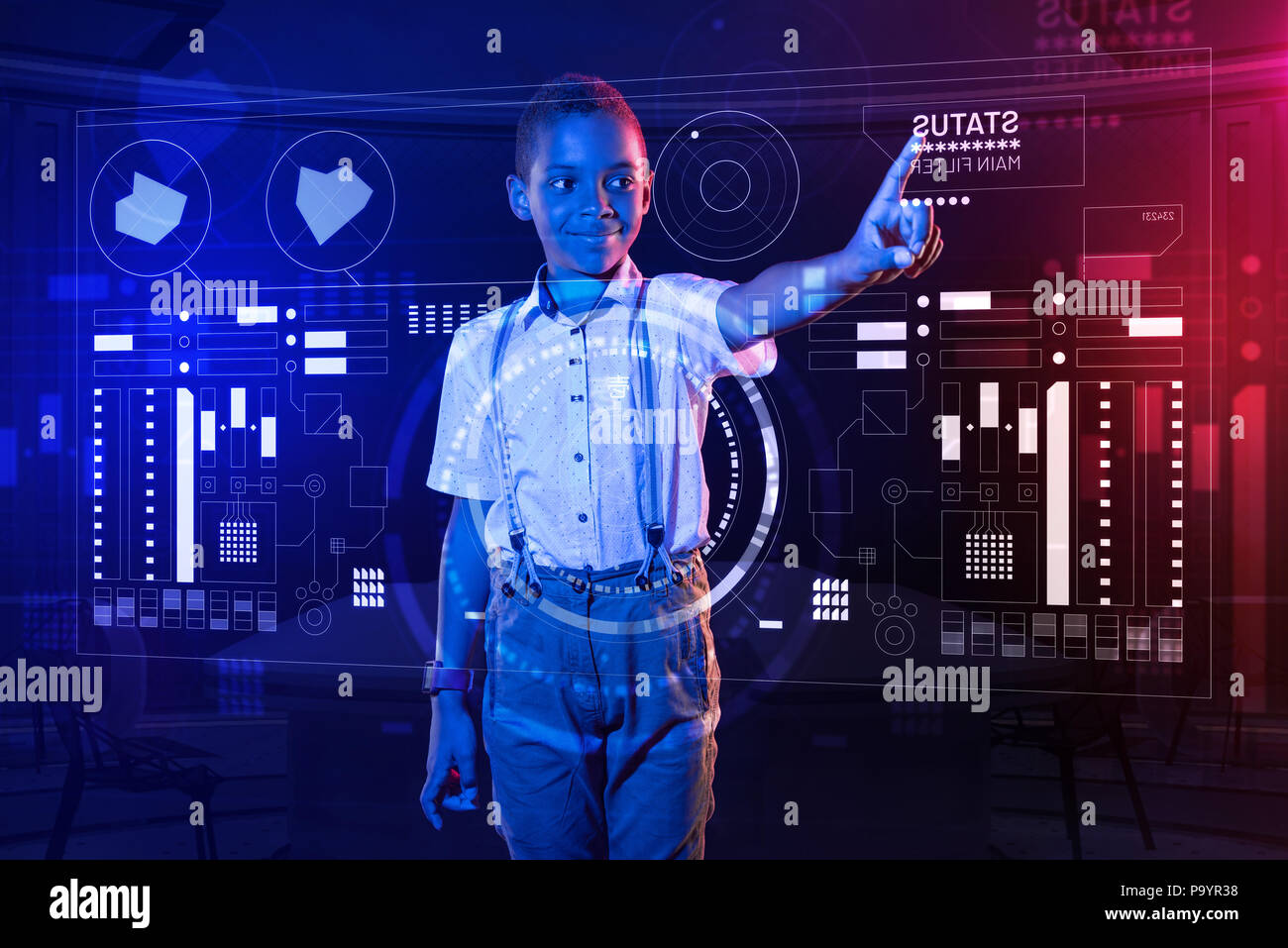 Happy boy using a futuristic device and smiling Stock Photo - Alamy