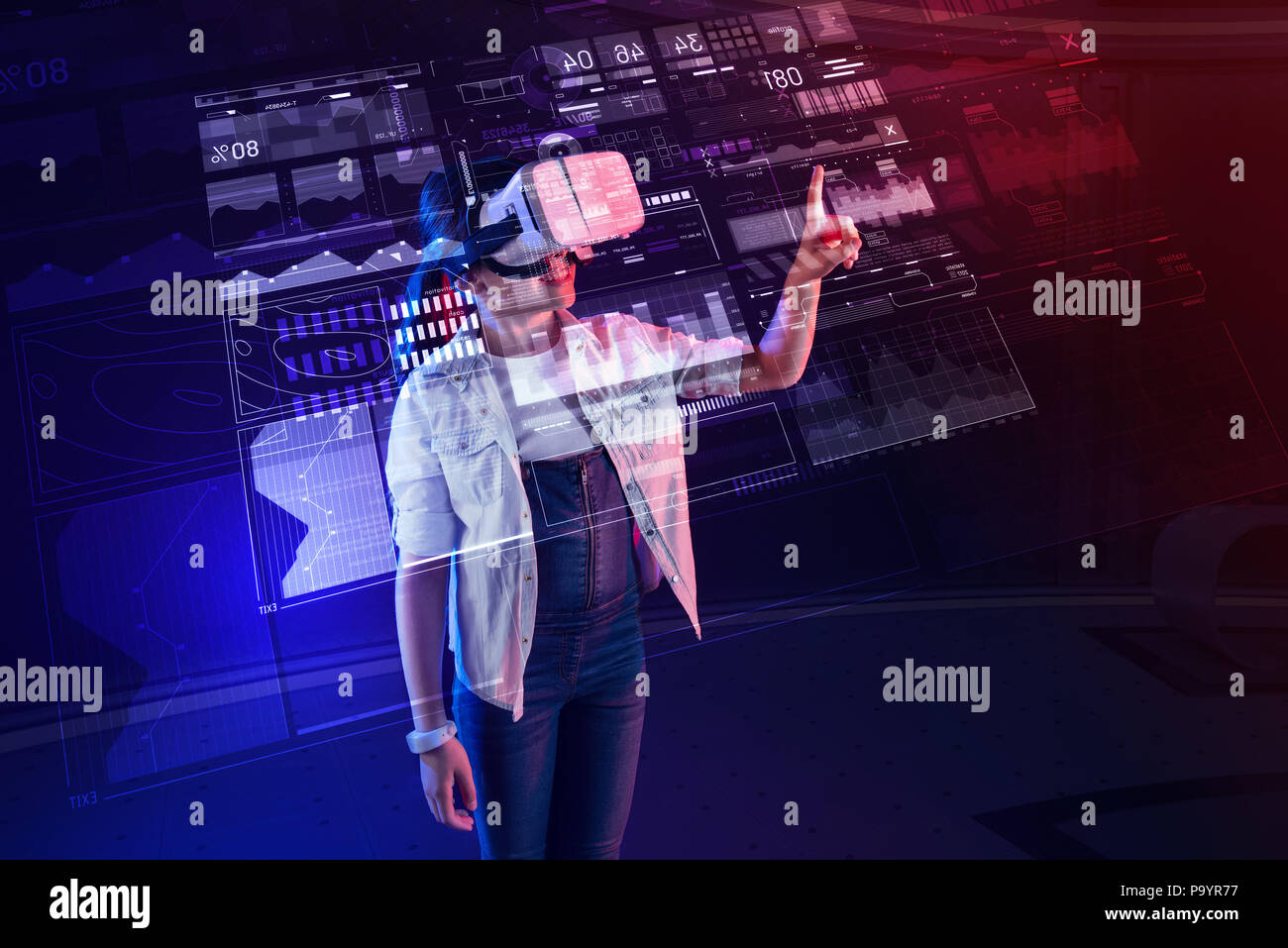Calm girl touching the hologram and wearing virtual reality glasses ... Calm girl touching the hologram and wearing virtual reality glasses ...