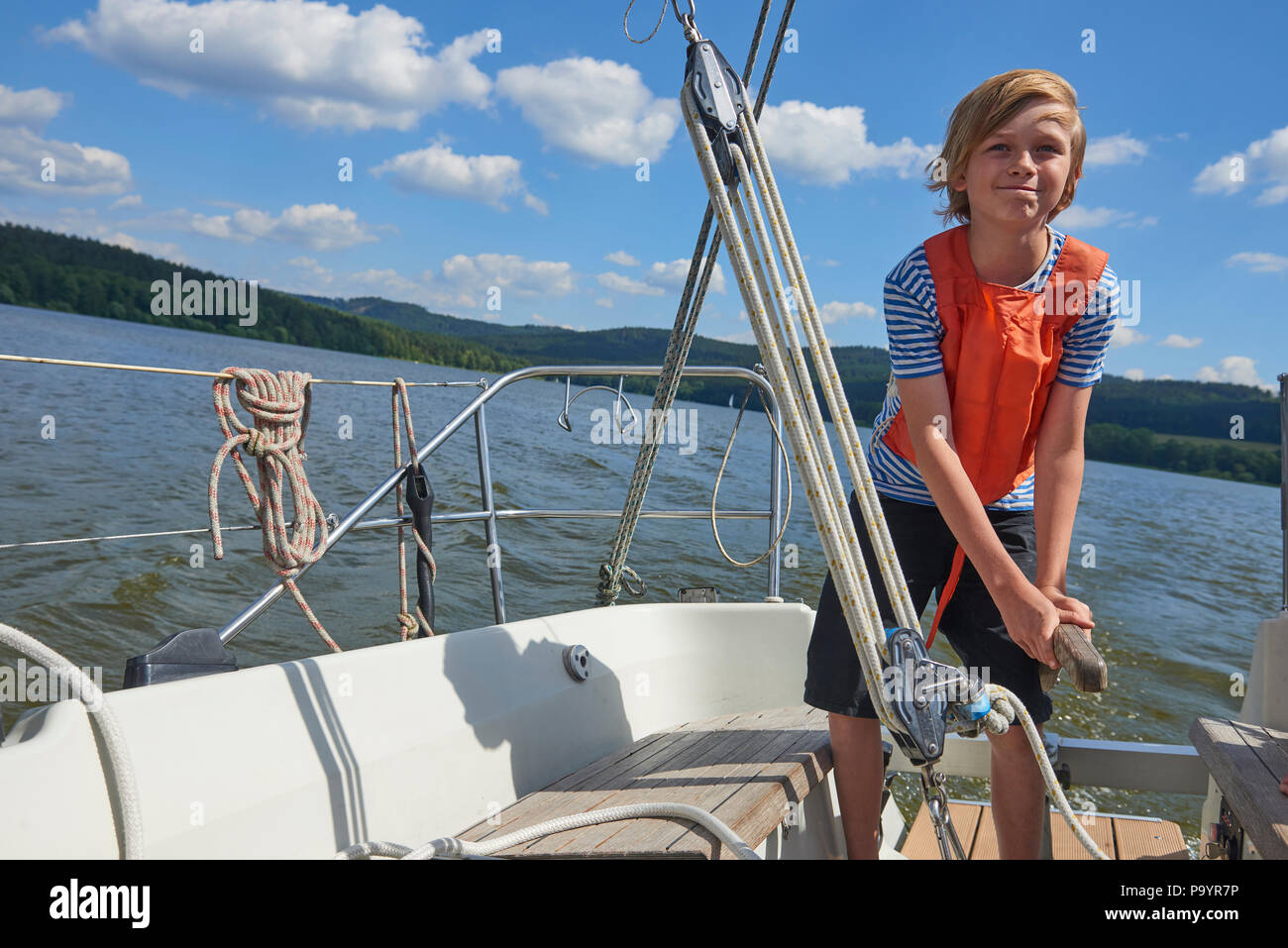 Child boy holding a yacht rudder. Cute boy captain on board of sailing ...