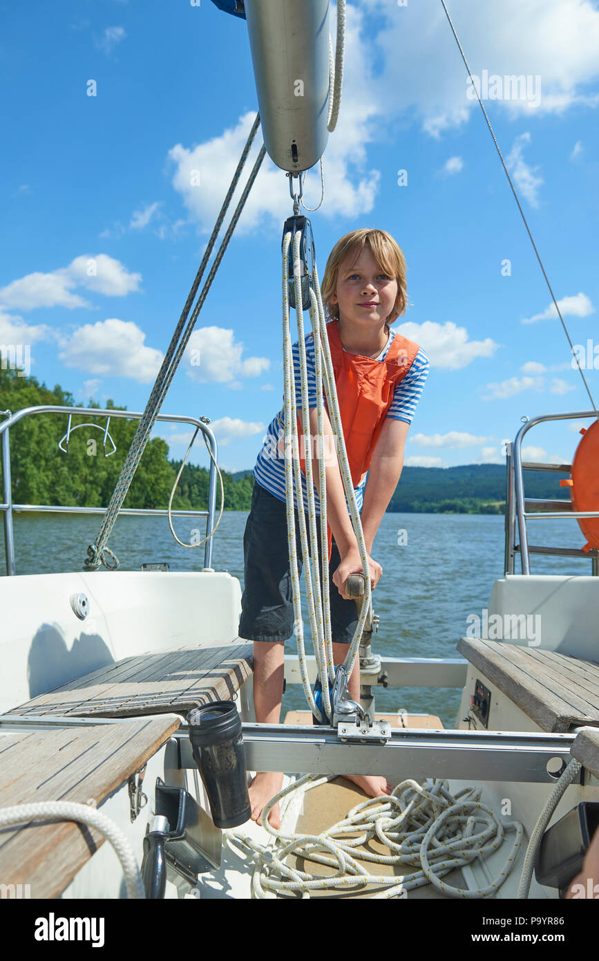 Child boy holding a yacht rudder. Cute boy captain on board of sailing ...