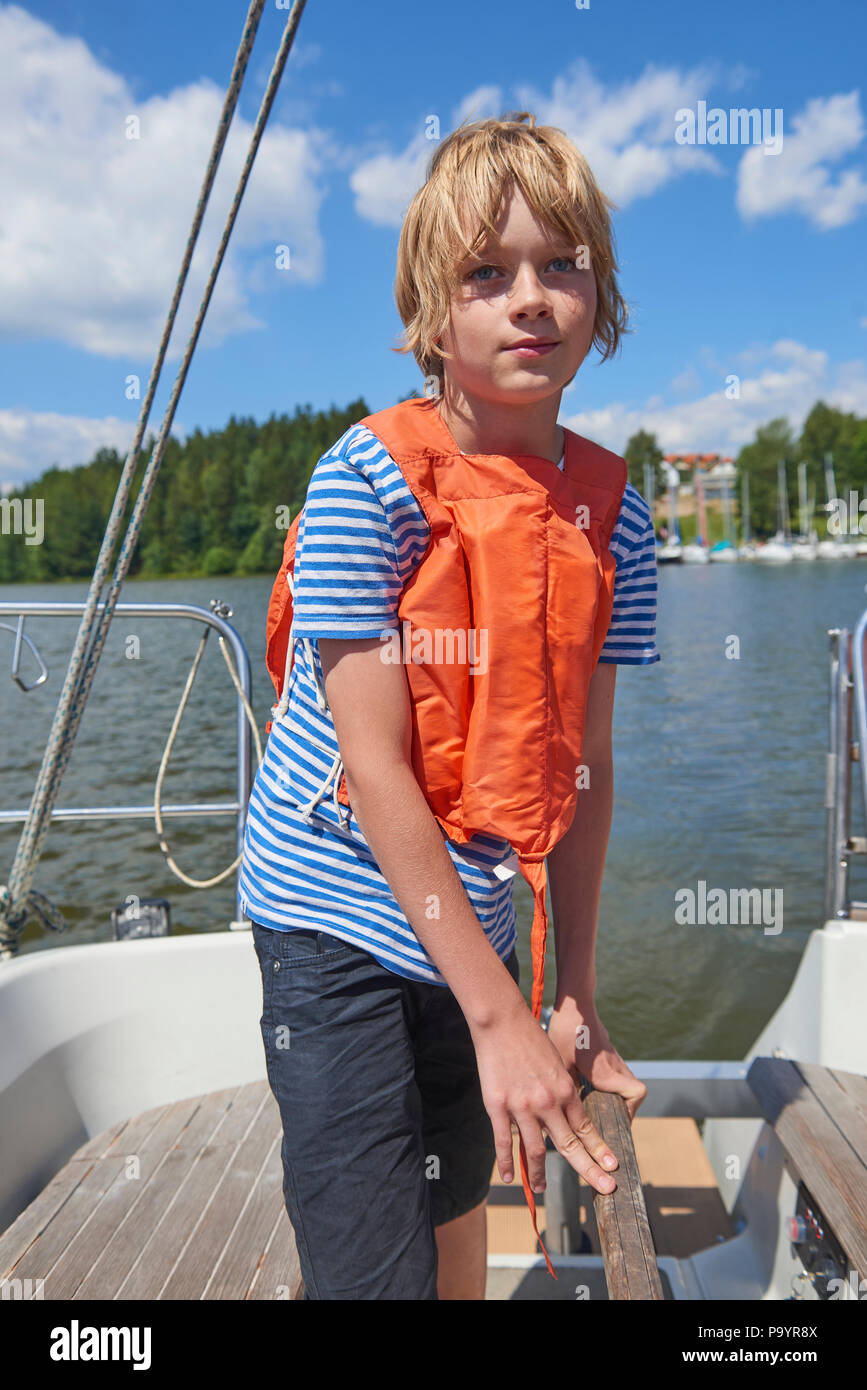 Child boy holding a yacht rudder. Cute boy captain on board of sailing ...