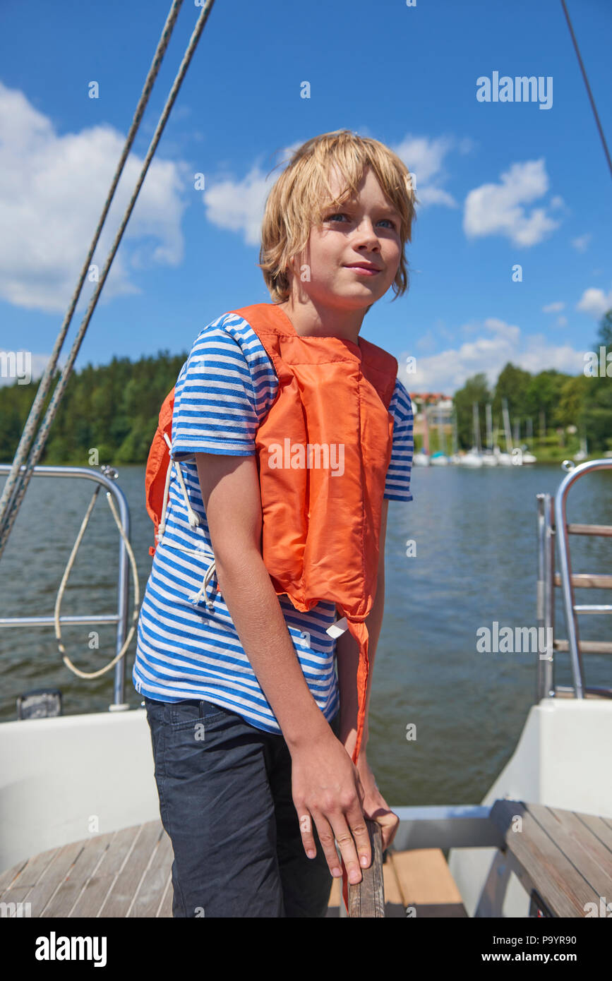 Child boy holding a yacht rudder. Cute boy captain on board of sailing ...