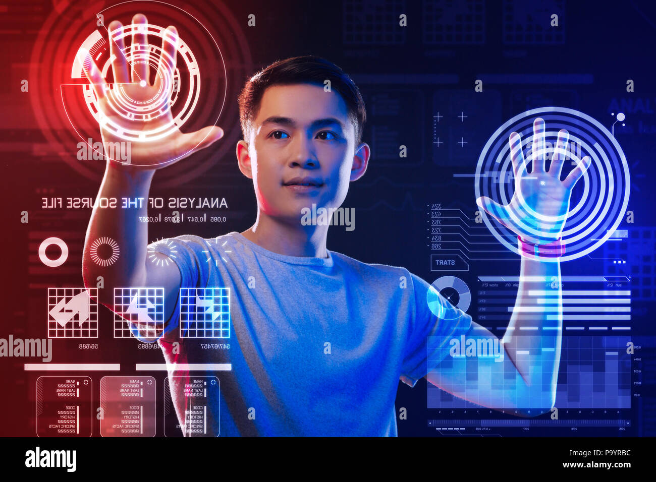 Calm young man touching the screen with two hands while working Stock ...