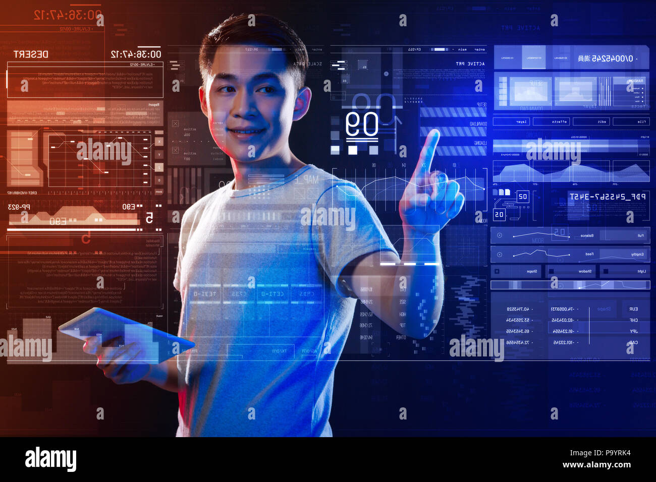 Cheerful programmer standing with a tablet and working Stock Photo - Alamy