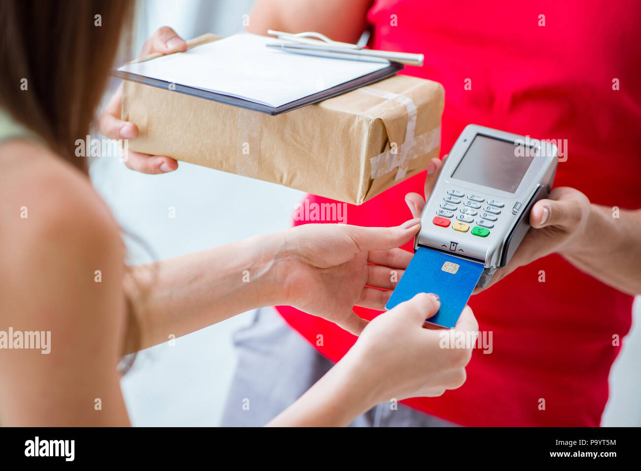 Parcel delivery being paid with pos and credit card Stock Photo - Alamy