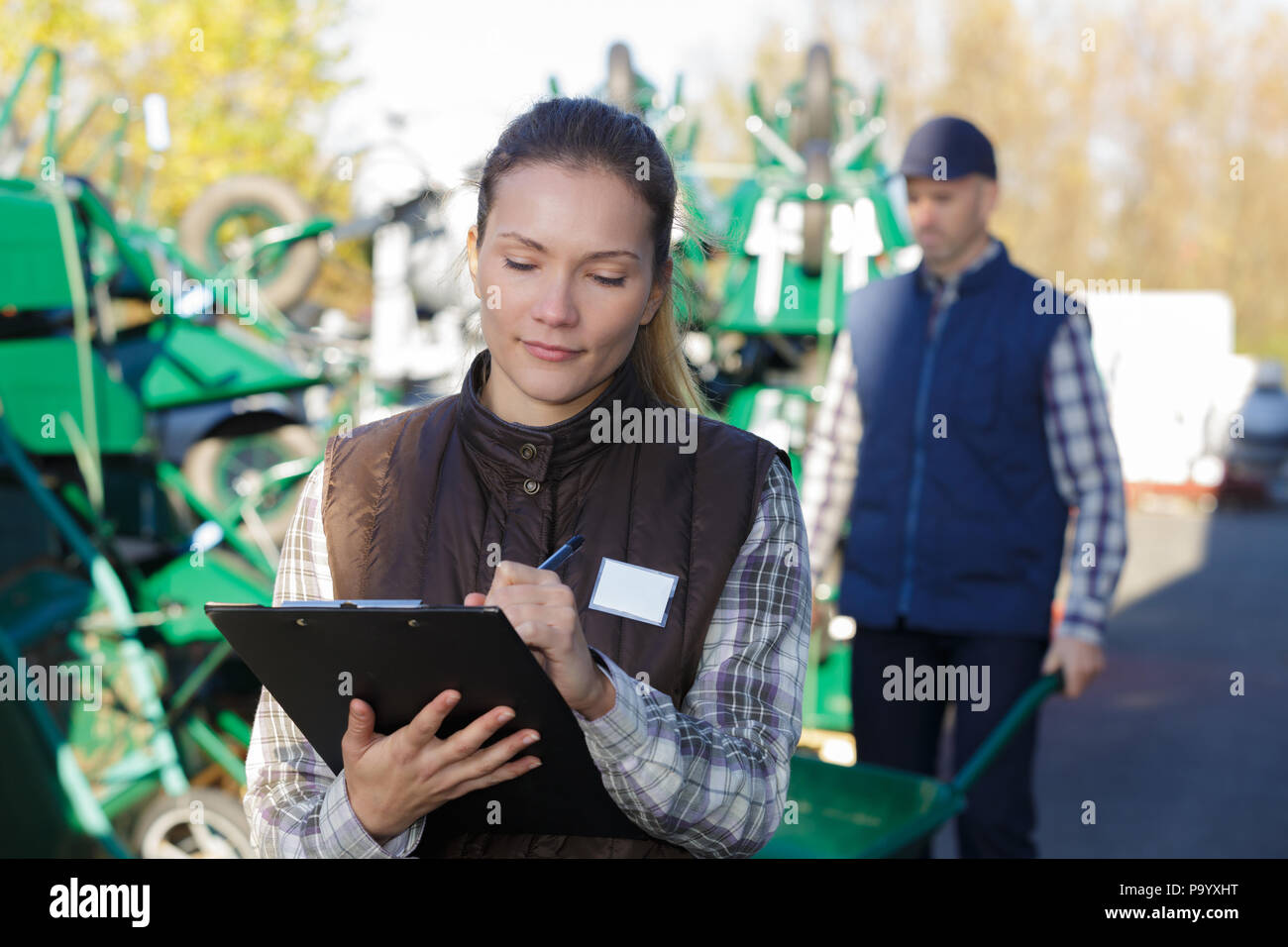 businesswoman writing on clipboard outside a factory Stock Photo - Alamy