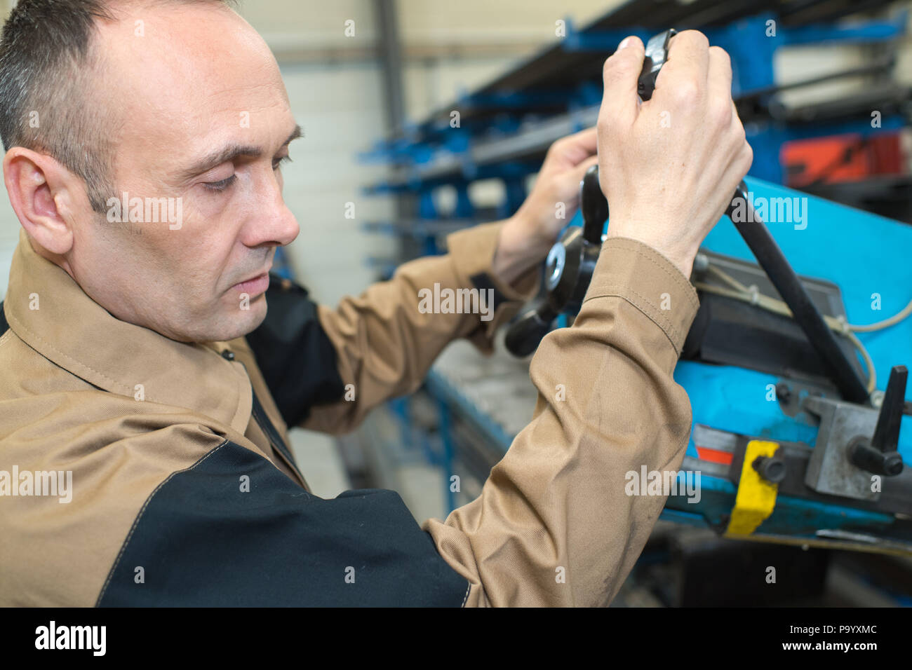 Mechanic holding lever on machine Stock Photo - Alamy