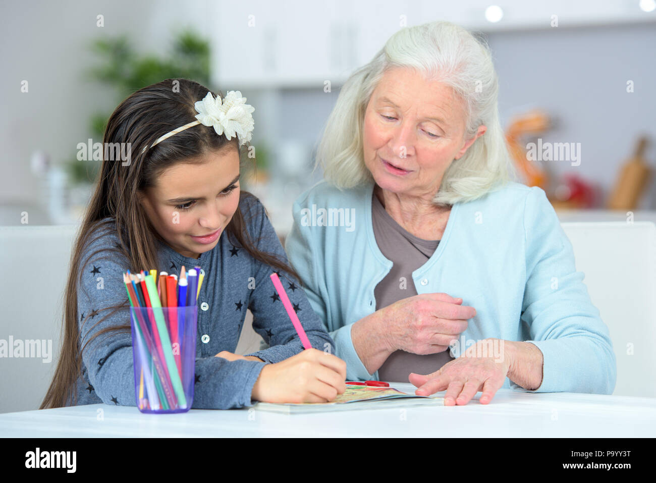 grandchild drawing at home with grandmother Stock Photo - Alamy