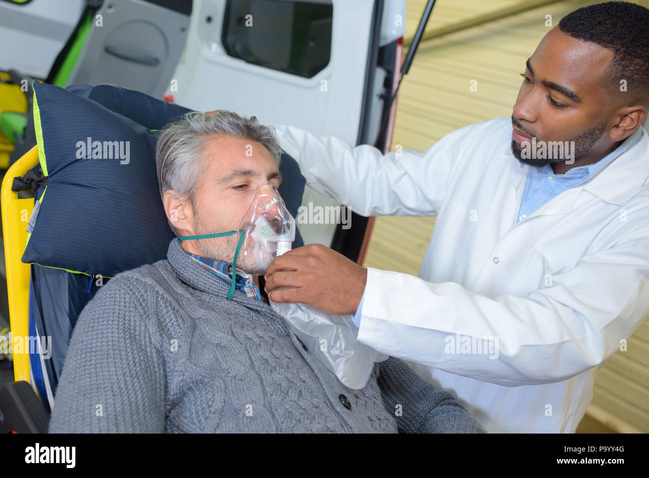 Paramedic holding oxygen mask on patient Stock Photo - Alamy