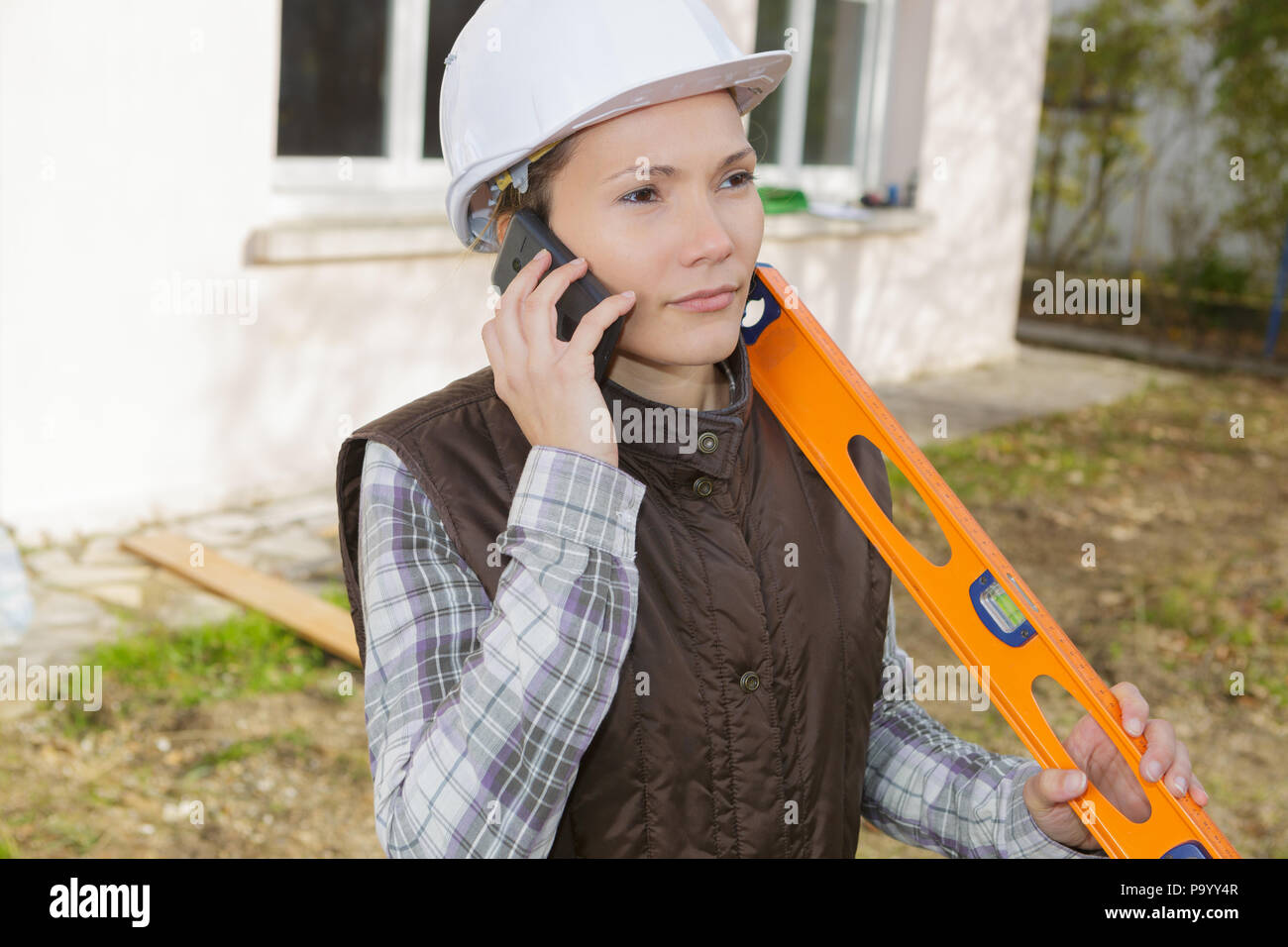 female construction worker with level outside construction site Stock ...