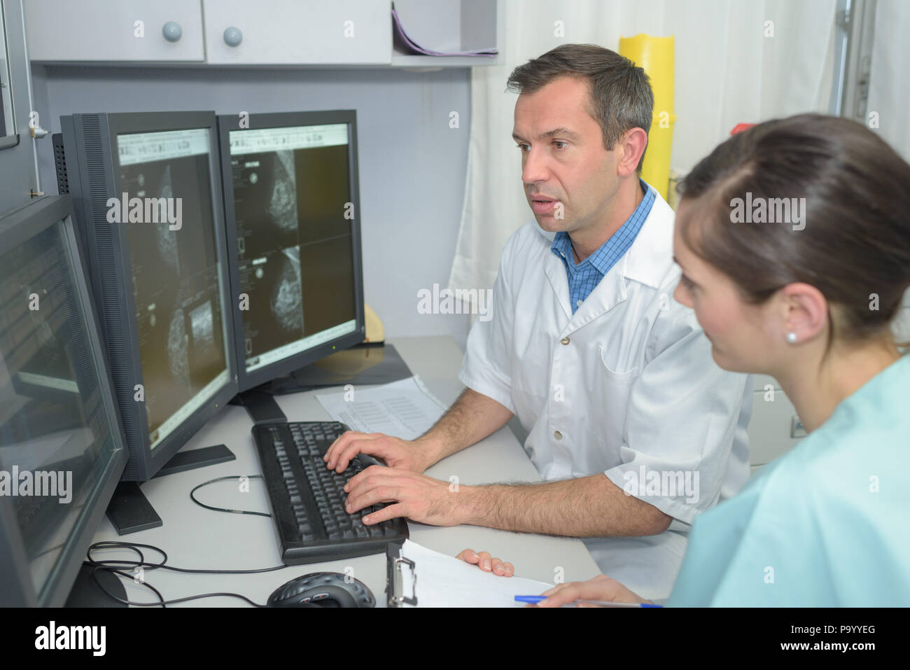 doctors checking xray on a computers screen on a desk Stock Photo - Alamy