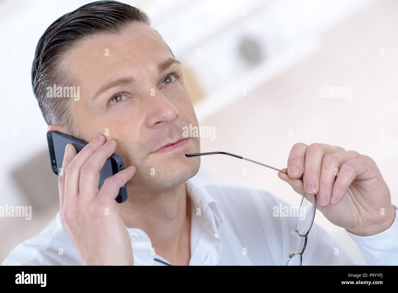 male indoors calling while being concentrated Stock Photo - Alamy
