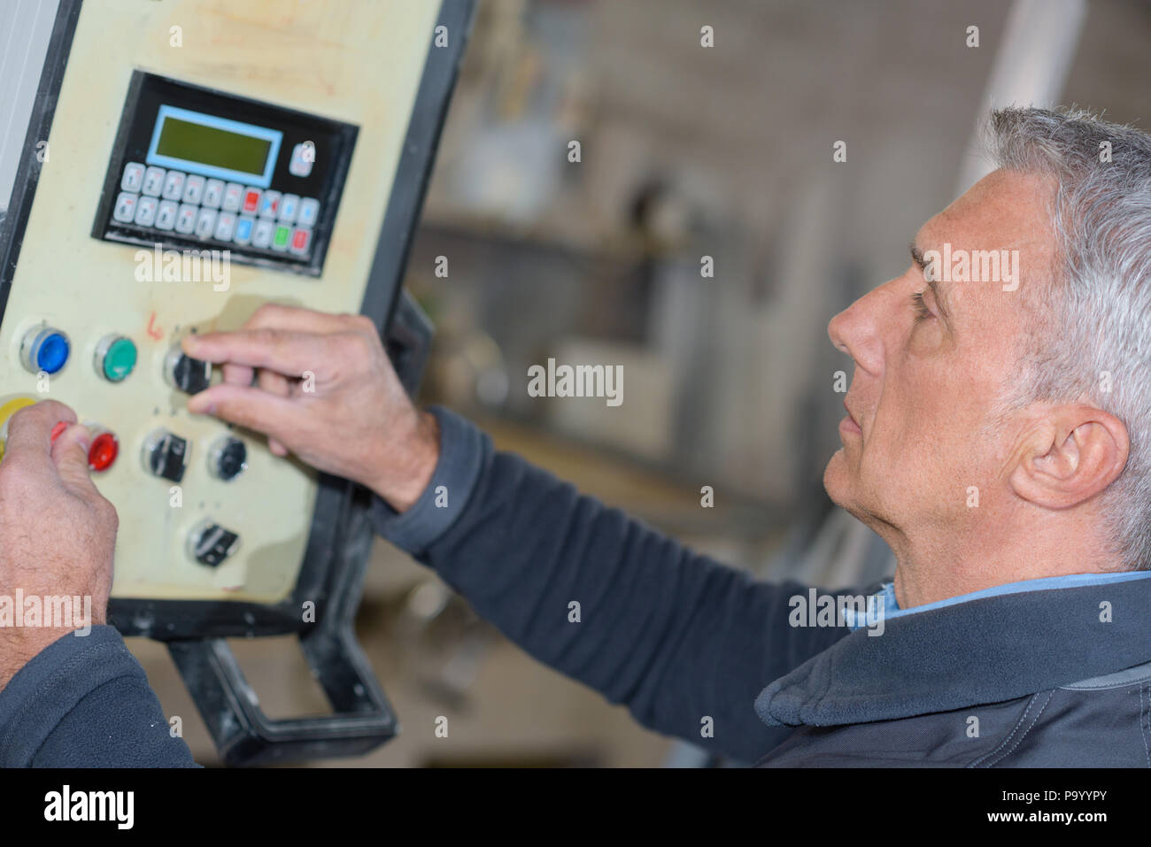 worker in factory using machine Stock Photo - Alamy
