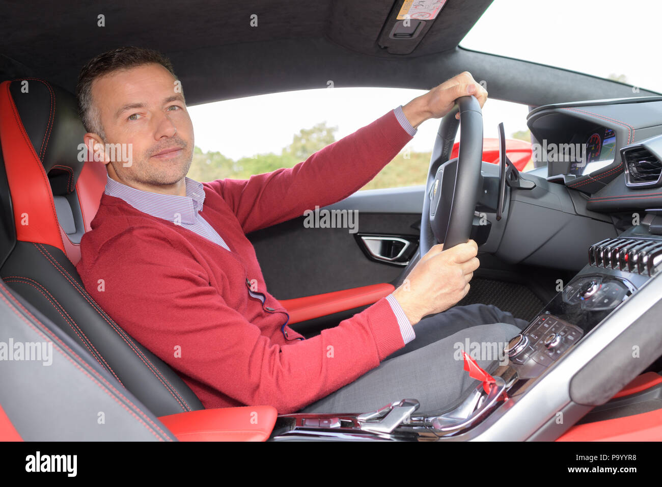 man driving a red car Stock Photo - Alamy
