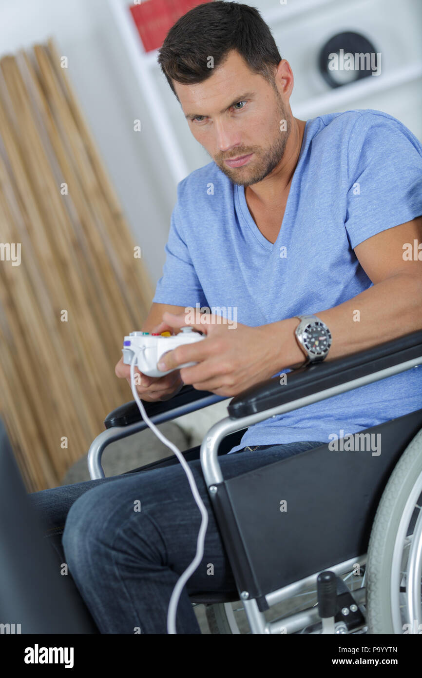 man in wheelchair playing computer game Stock Photo - Alamy