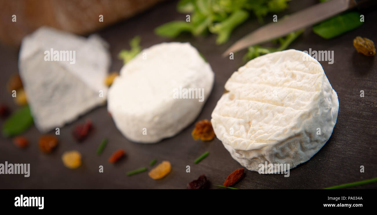 French goats cheeses and bread on background, France Stock Photo - Alamy