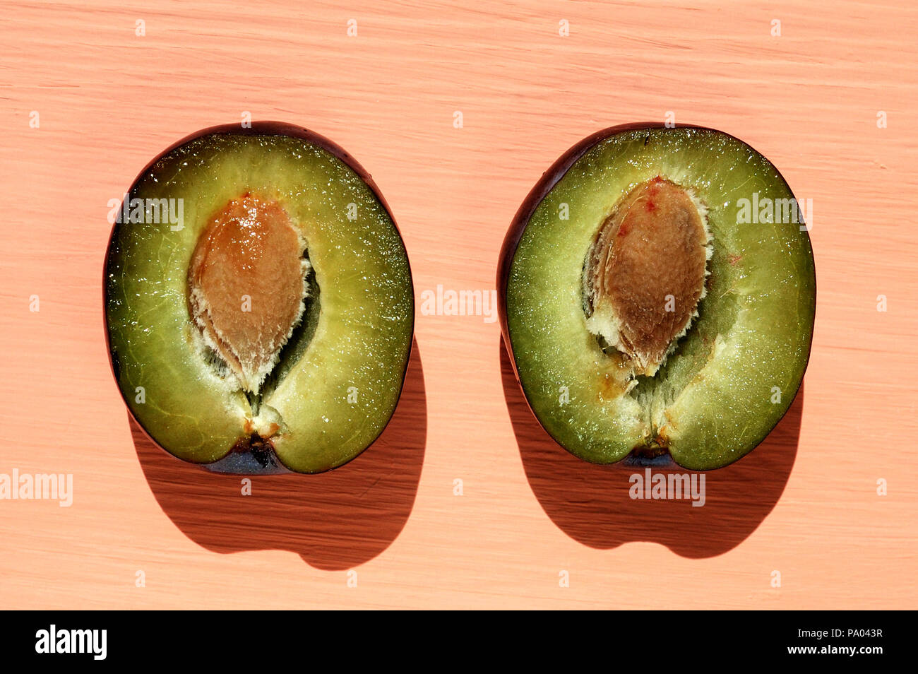 Plums cut in half with bones Stock Photo - Alamy
