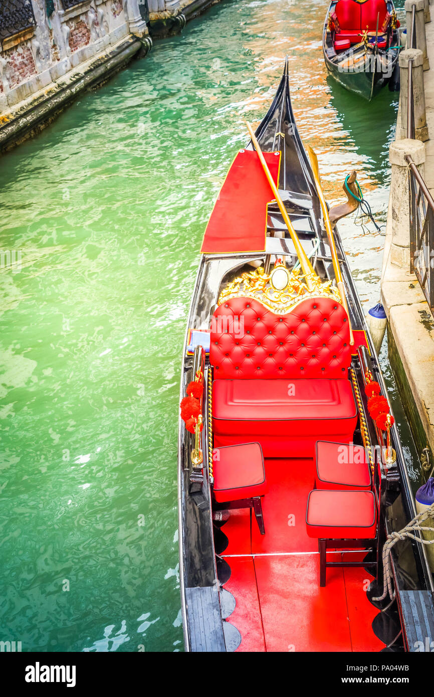 Venetian gondola with red leather chair in water, toned Stock Photo - Alamy