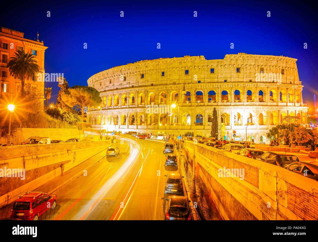 view of Colosseum illuminated at nighwith traffic lightst in Rome ...