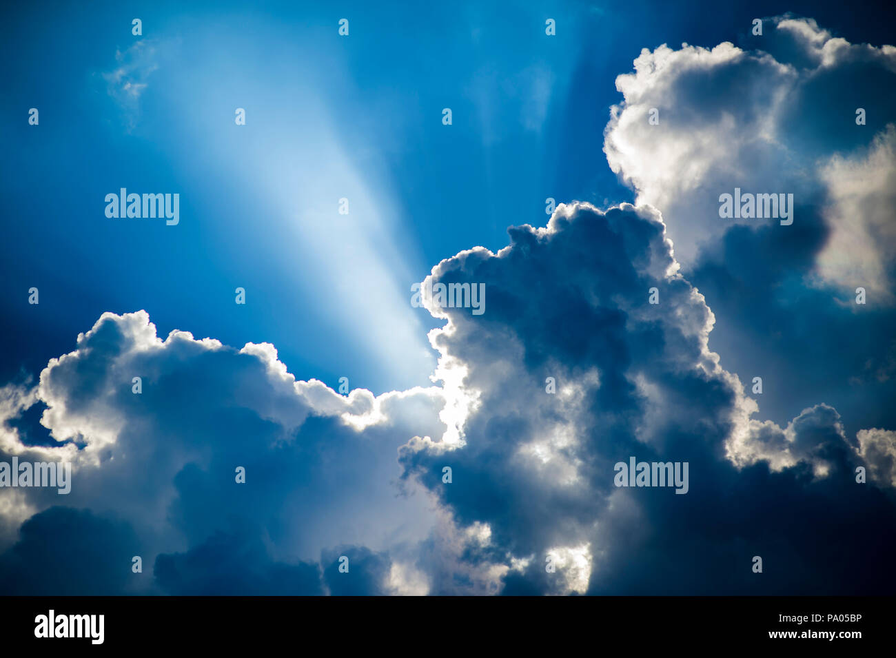Abstract view of puffy summer thunderstorm clouds backlit by sun with ...