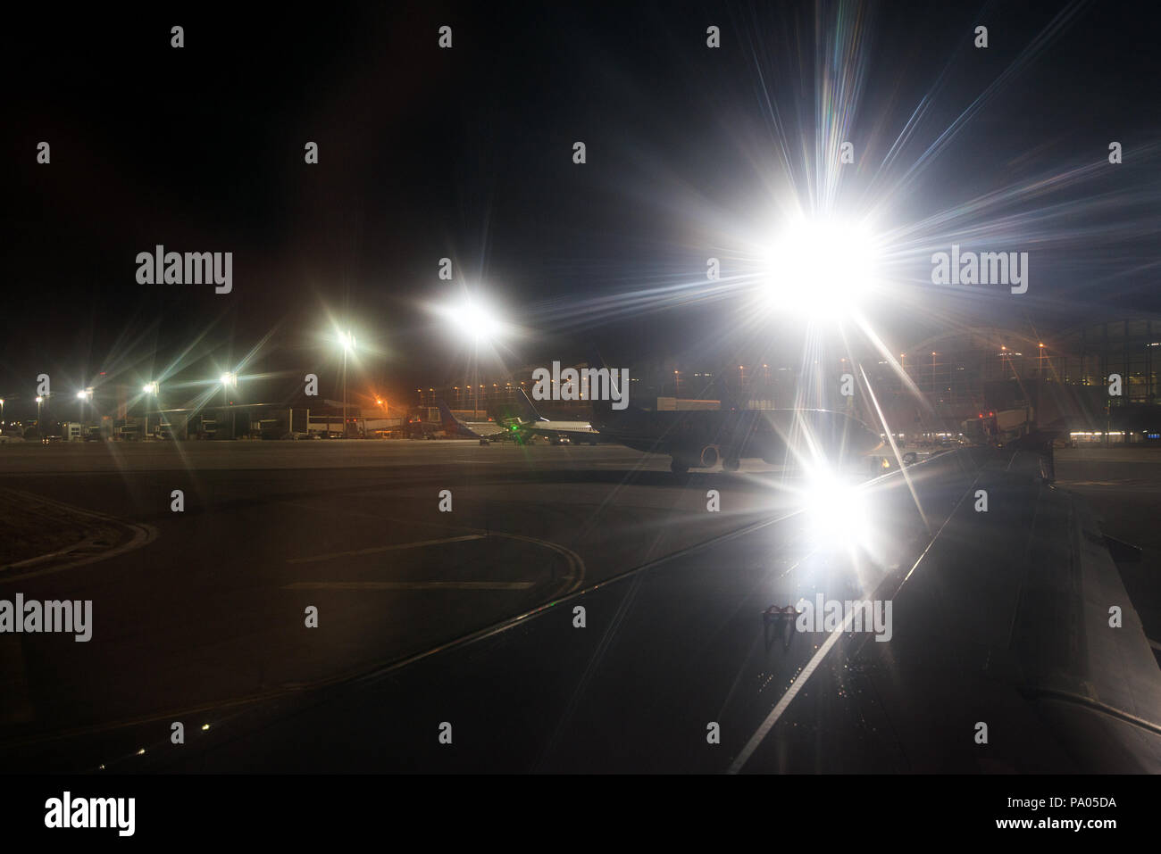 Night shot. Bright lights in airport. Plane has landed or is about to ...