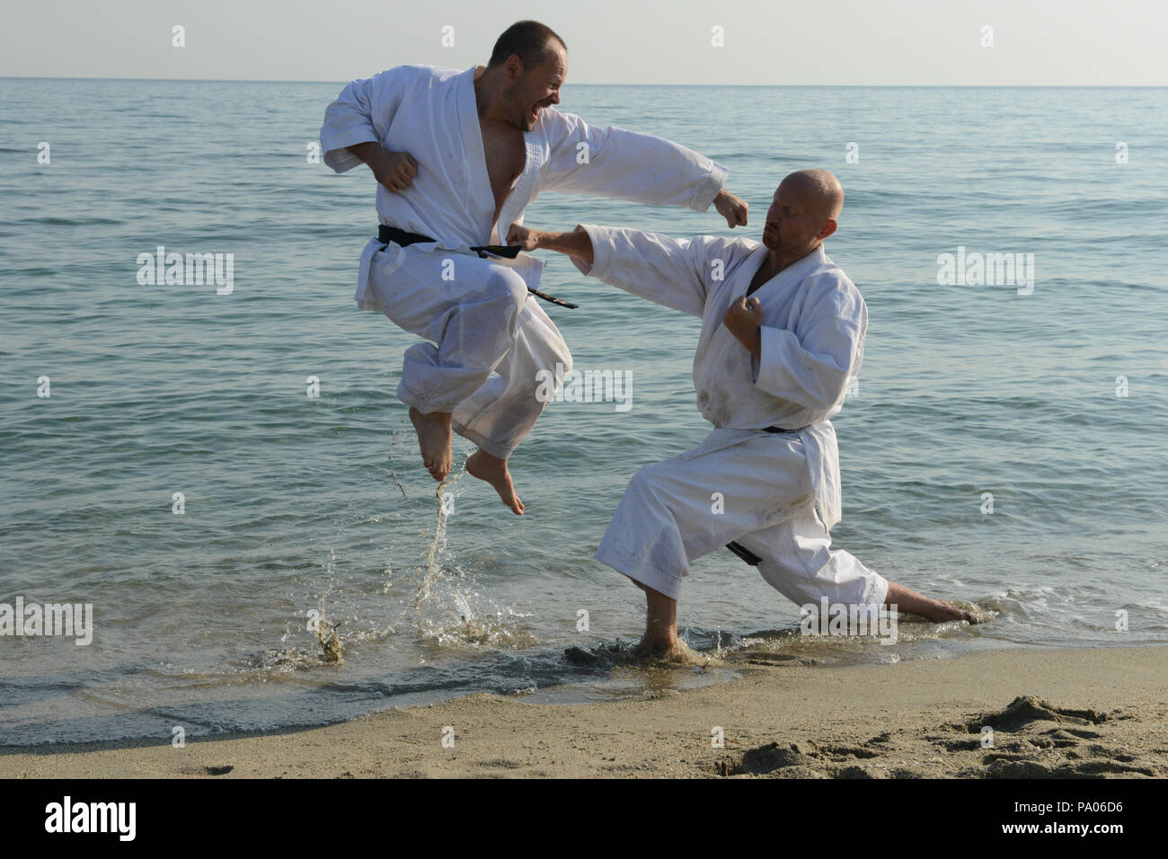 Two karate masters in a show fight at the beach Stock Photo - Alamy